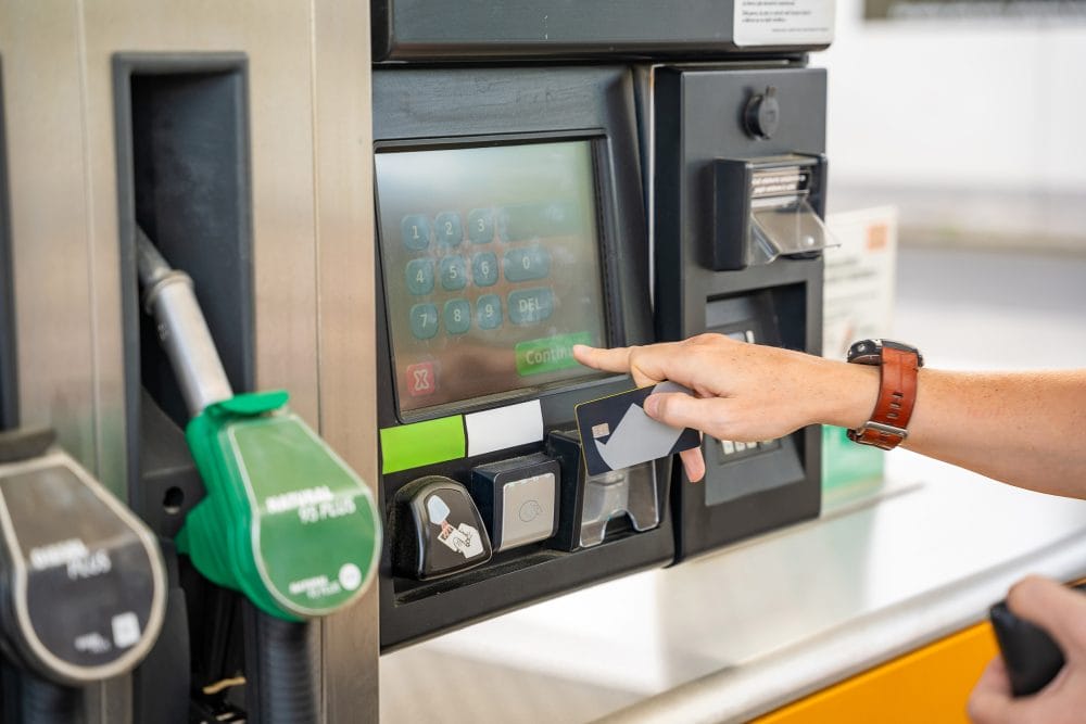 Close up view of man hand pays for fuel with a credit card on terminal ...